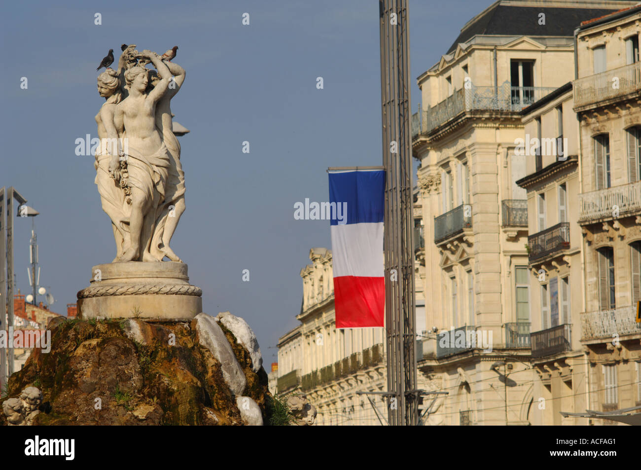 Fountain statues and French flag on the Place de la Comedie ...