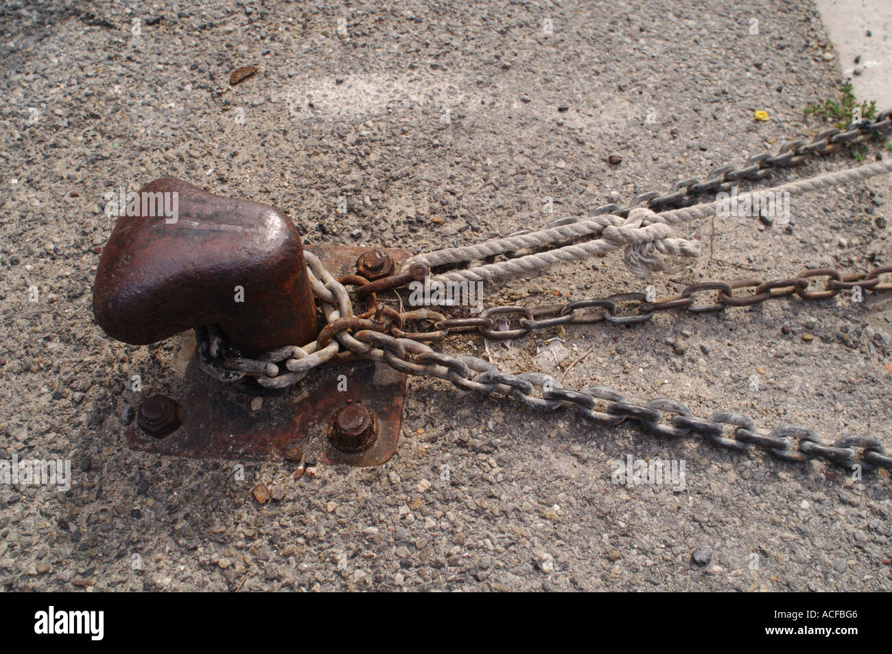 Multiple mooring ropes and chains made fast to a mooring bollard at a ...
