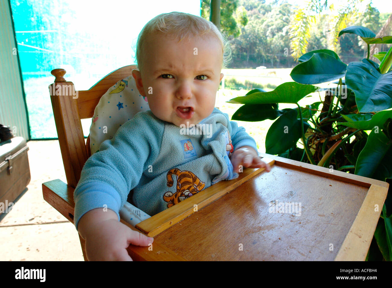 baby boy in highchair looking angry Stock Photo - Alamy