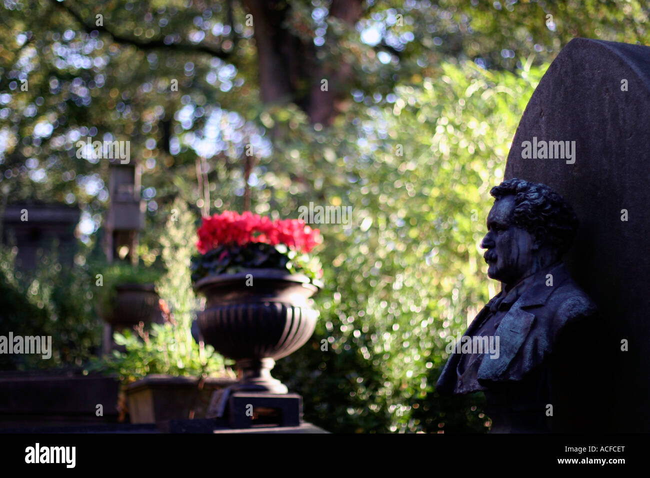 Bust monument surrounded by greenery and flowers in Père-Lachaise ...