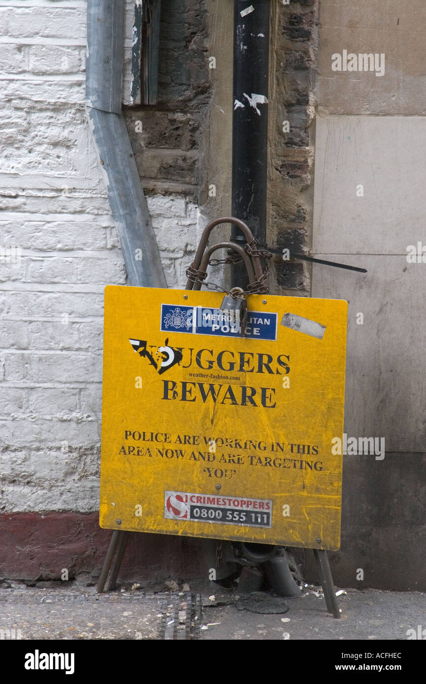 Yellow sign warning muggers of police presence in London UK Stock Photo ...