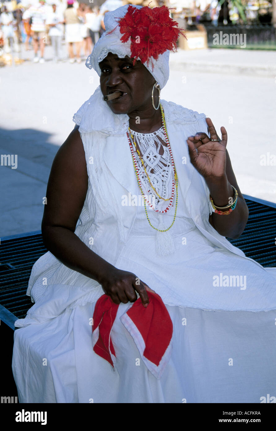 large elderly cuban lady sitting on a cuban street with cigar in her ...