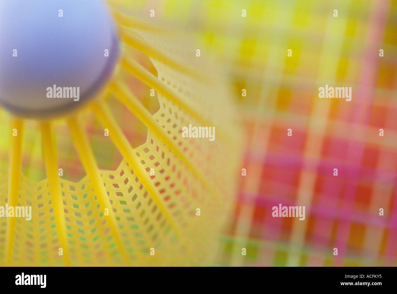 Close up of yellow shuttlecock birdie on badminton racket sunset light ...
