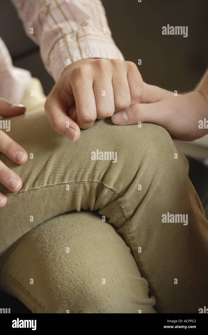 Woman holding the hand of another person on her lap Stock Photo - Alamy