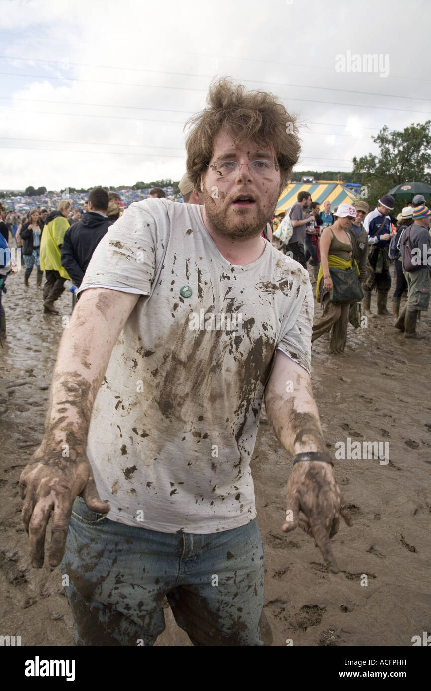 A muddy man dancing in a field of mud at the Glastonbury music festival ...