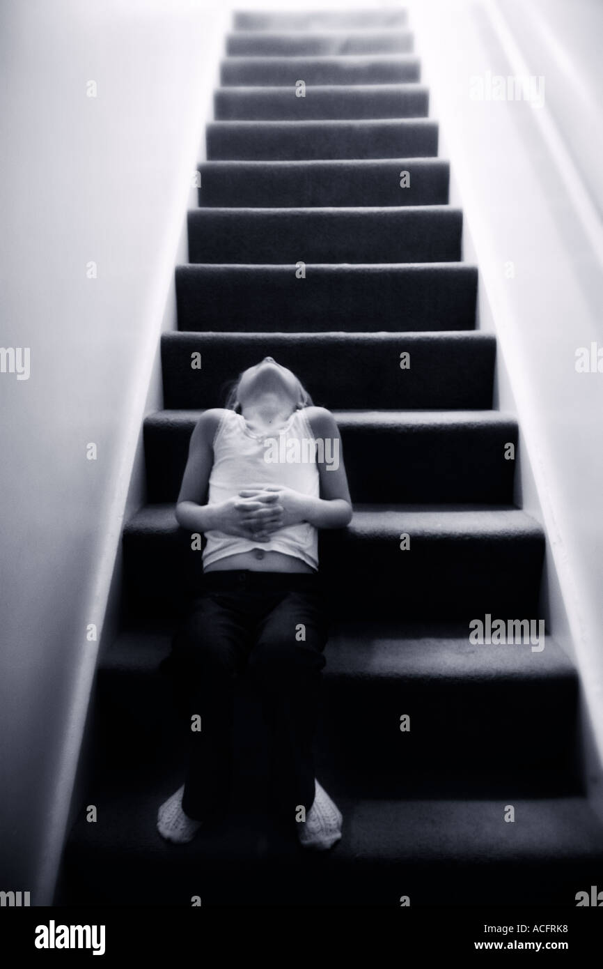 Photo of a girl sat at the bottom of the stairs looking up Stock Photo ...
