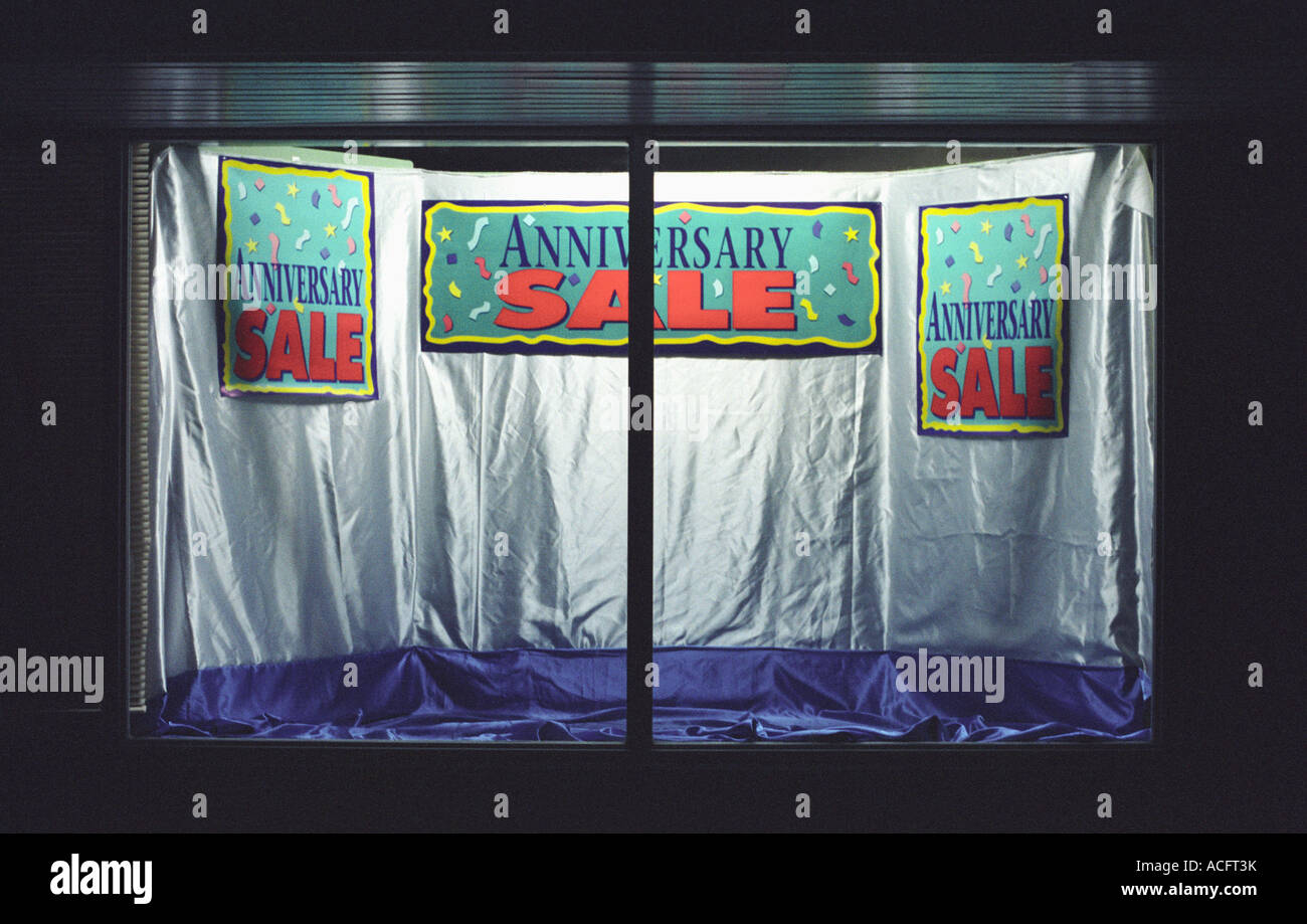 Shop window with sale signs sits empty after hours Stock Photo - Alamy