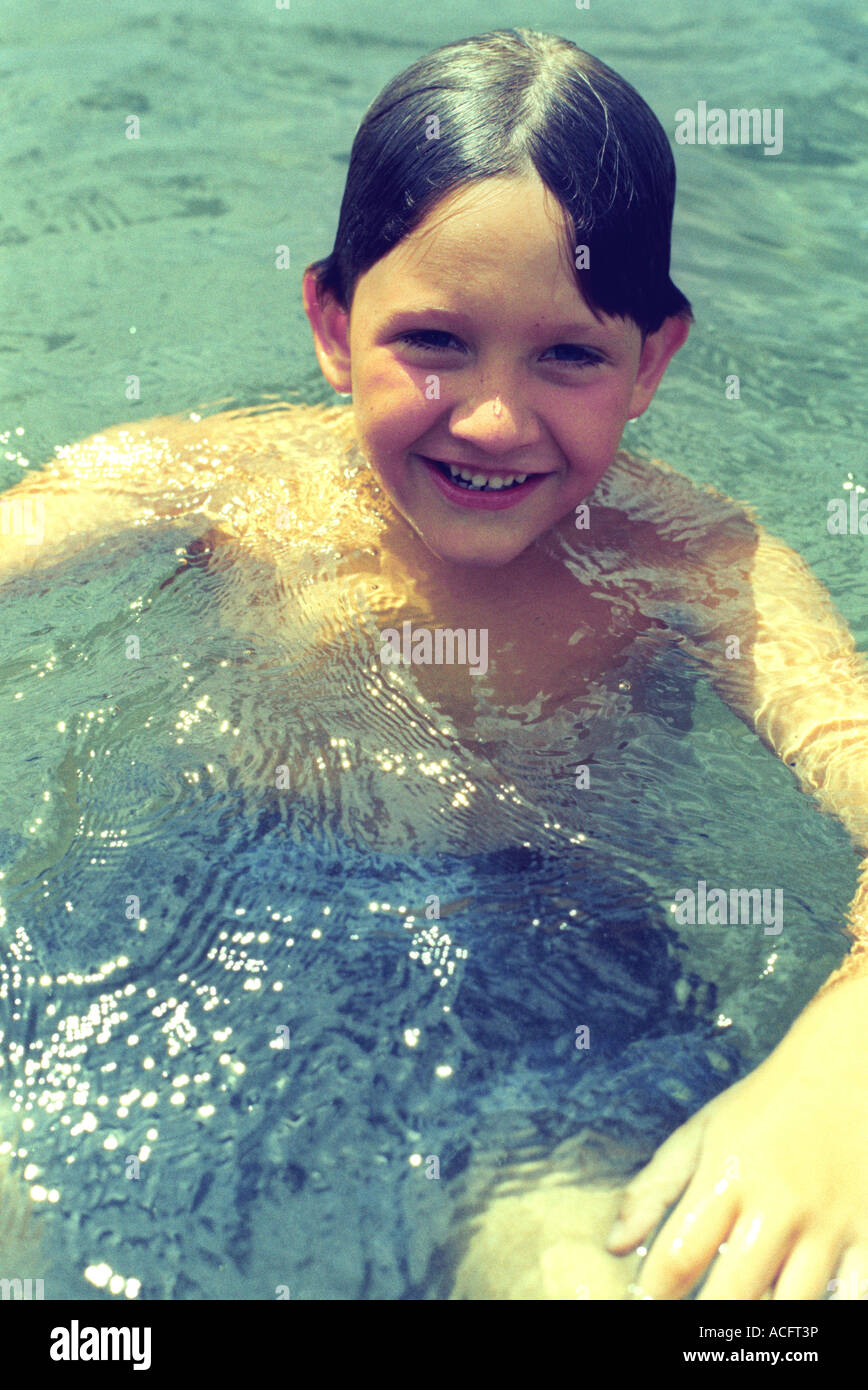 Young Boy sitting in water smiles looking at camera Model released ...