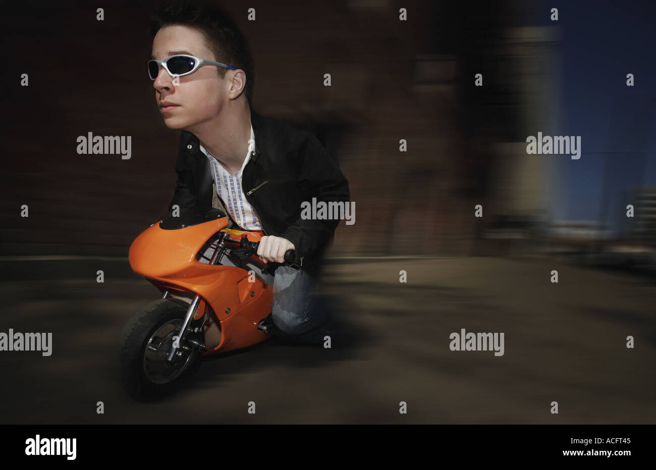Bizarre image of man riding on a mini motorcycle Stock Photo - Alamy