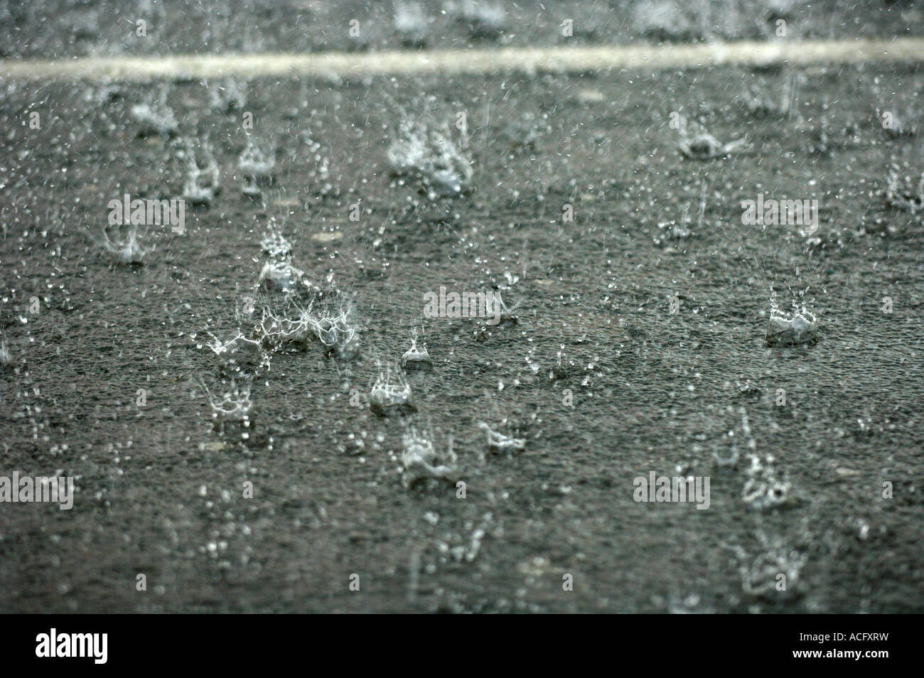 Raindrops splashing on car park in heavy rain storm Stock Photo - Alamy