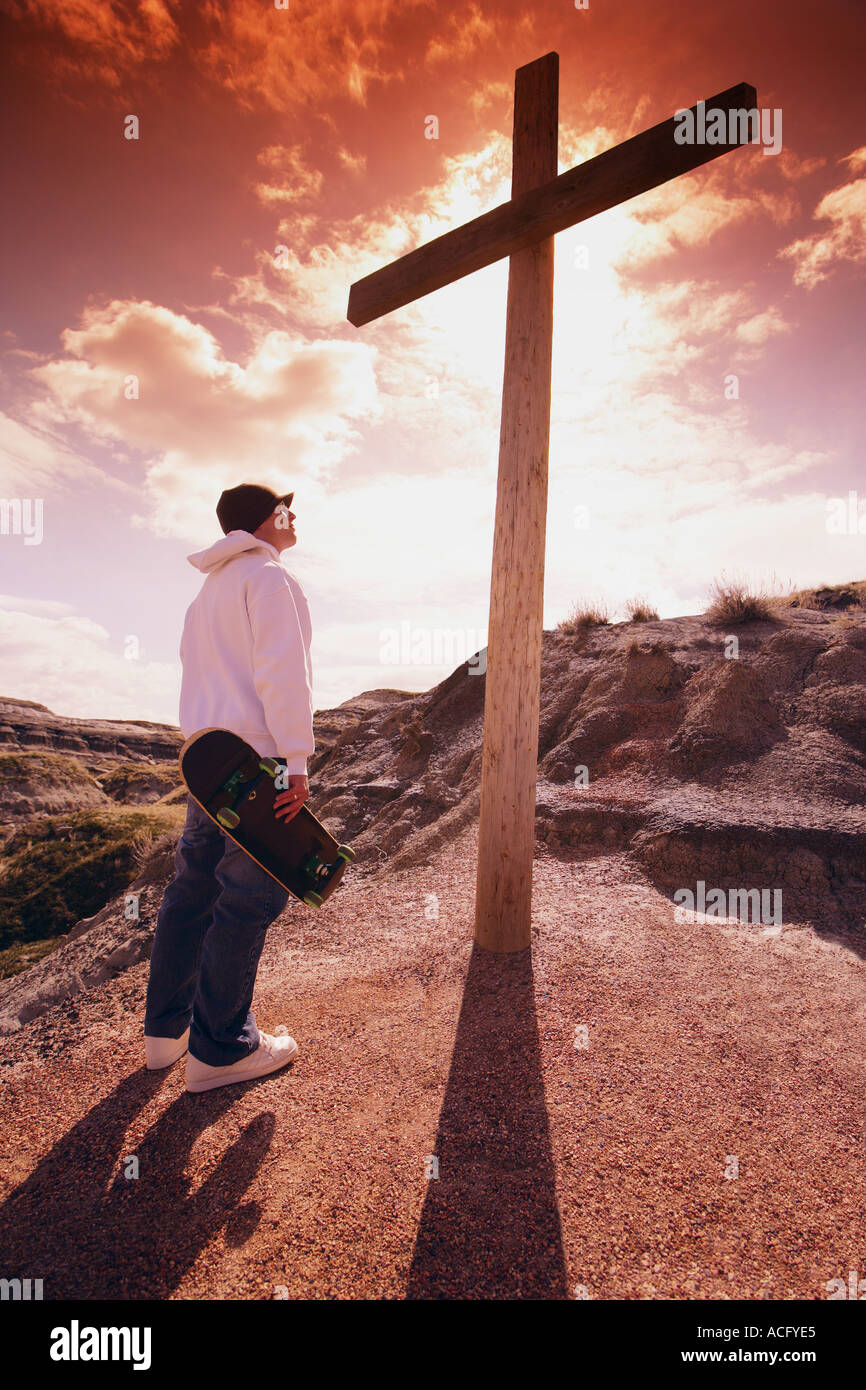 Skateboarder standing before a cross Stock Photo - Alamy