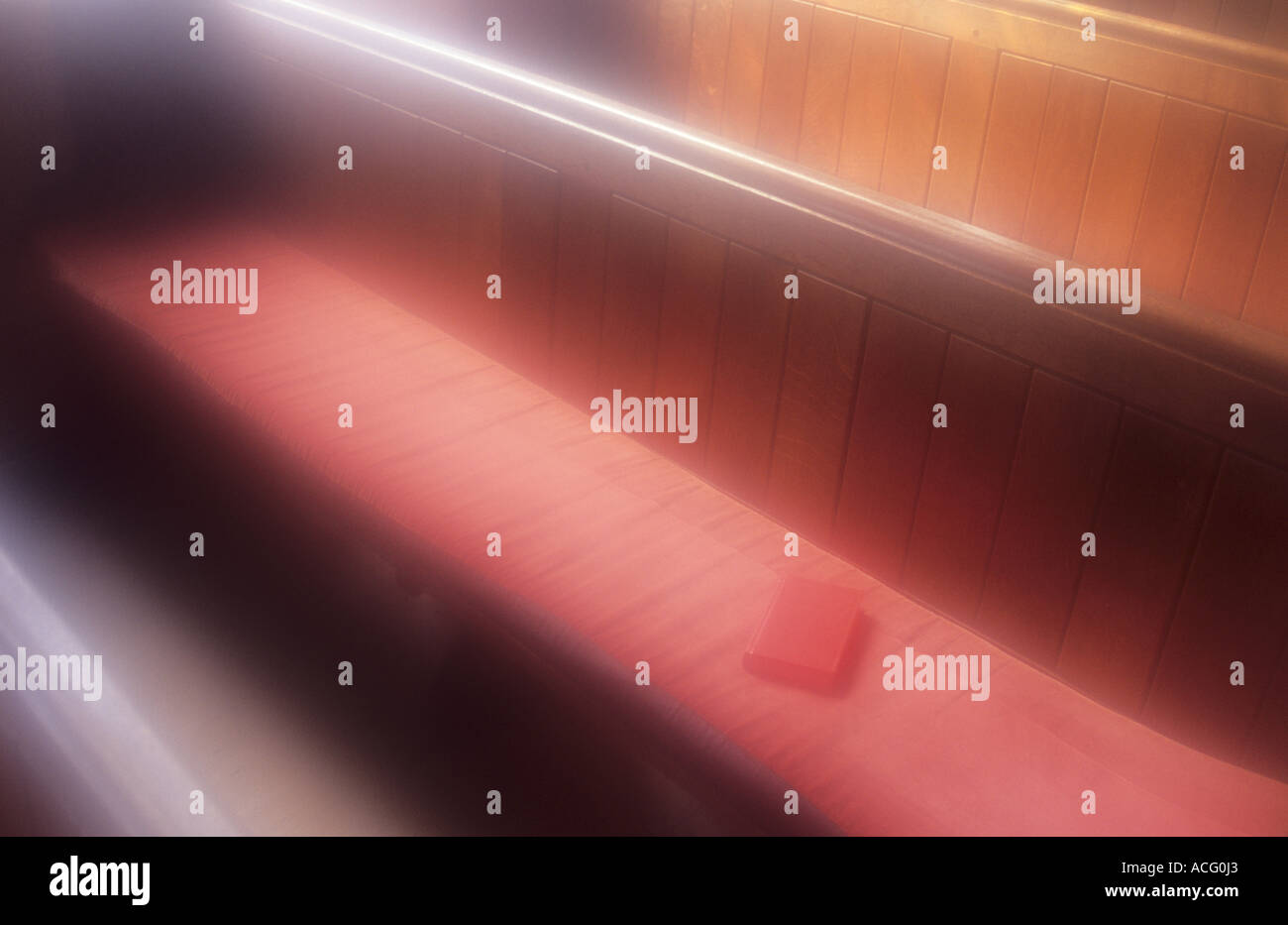 Atmospheric simple wooden church pews with long red seating cushions ...