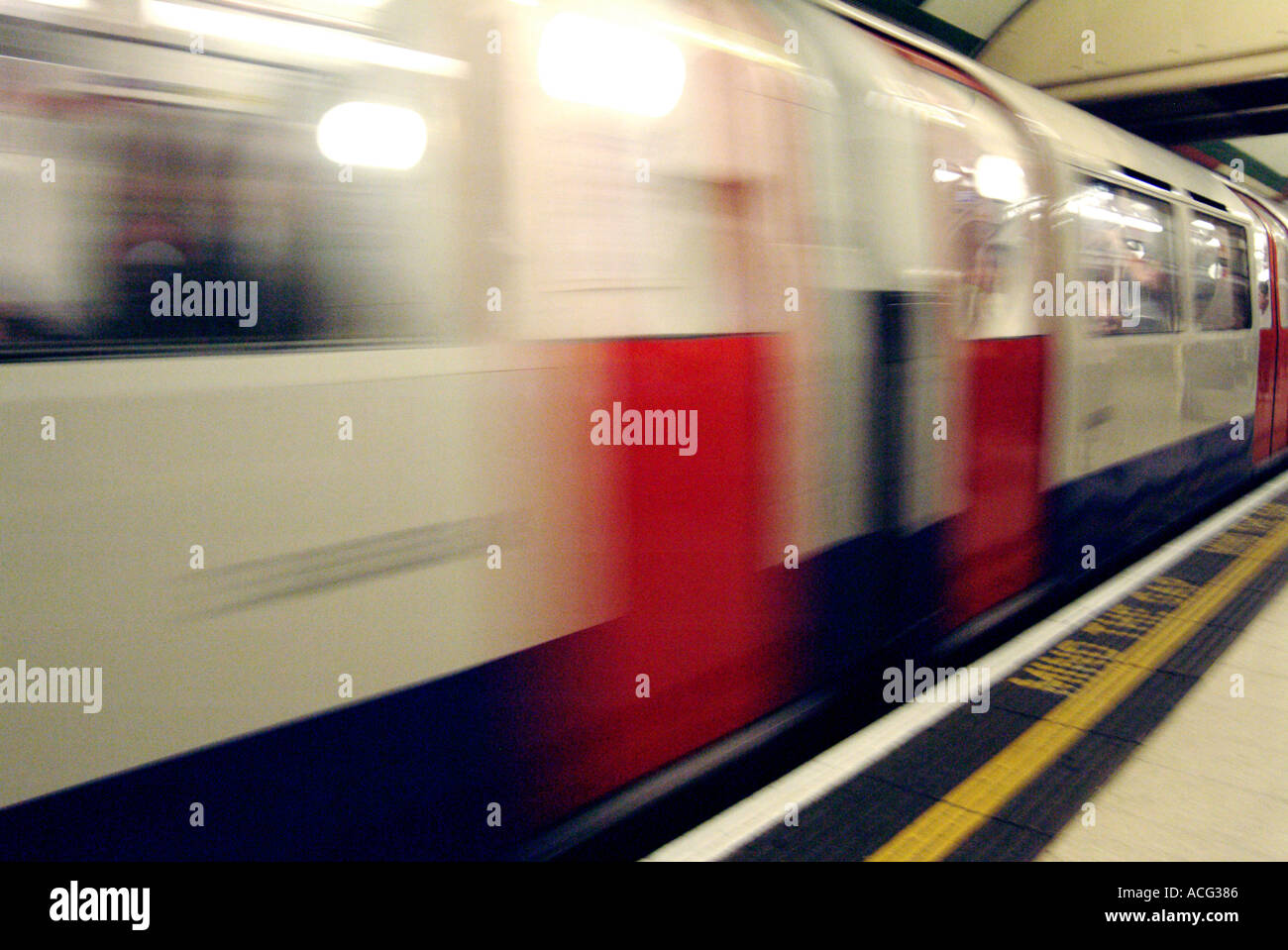 London Underground tube train speeds past a station platform Stock ...