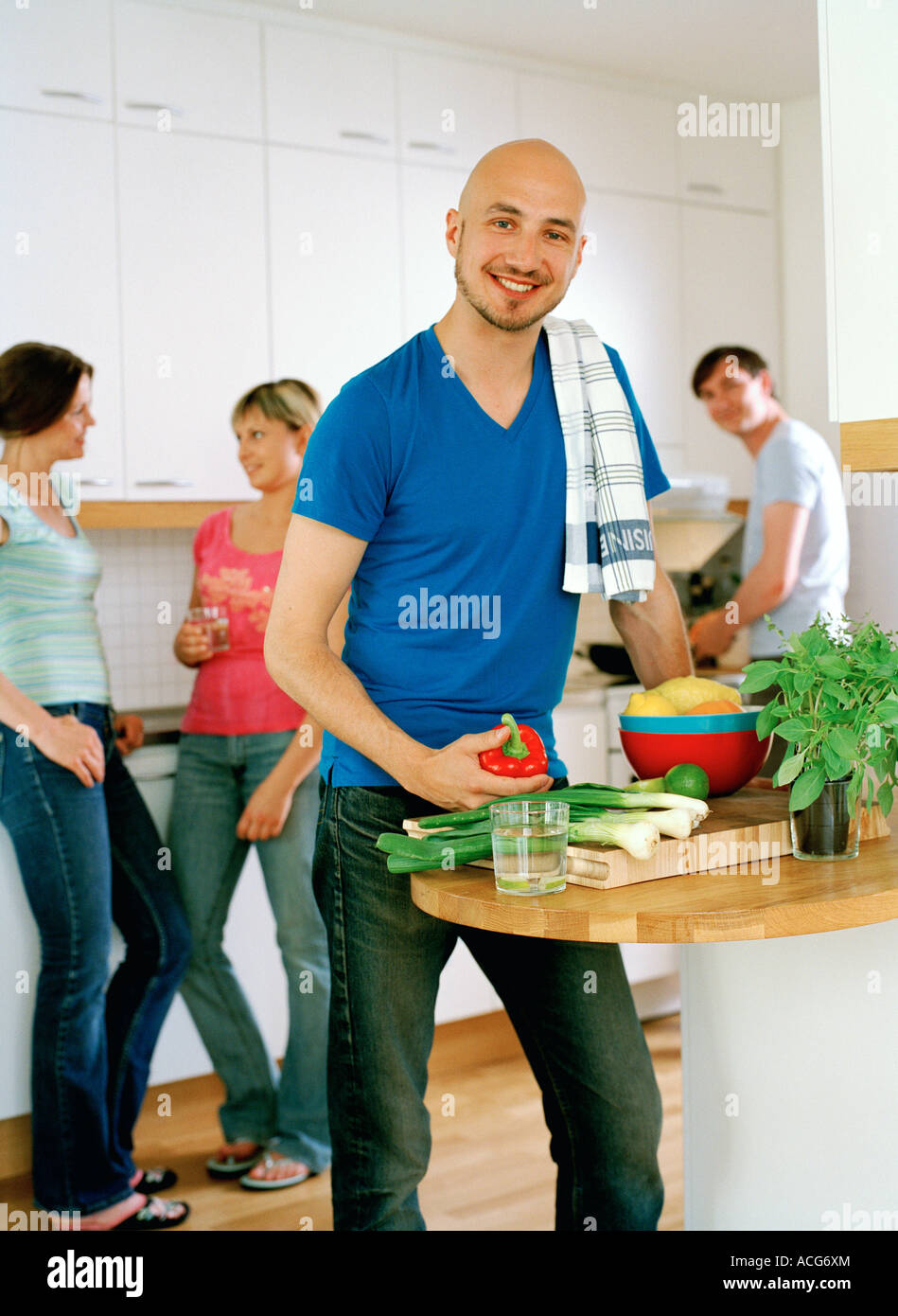 Four people preparing food in a kitchen Stock Photo - Alamy