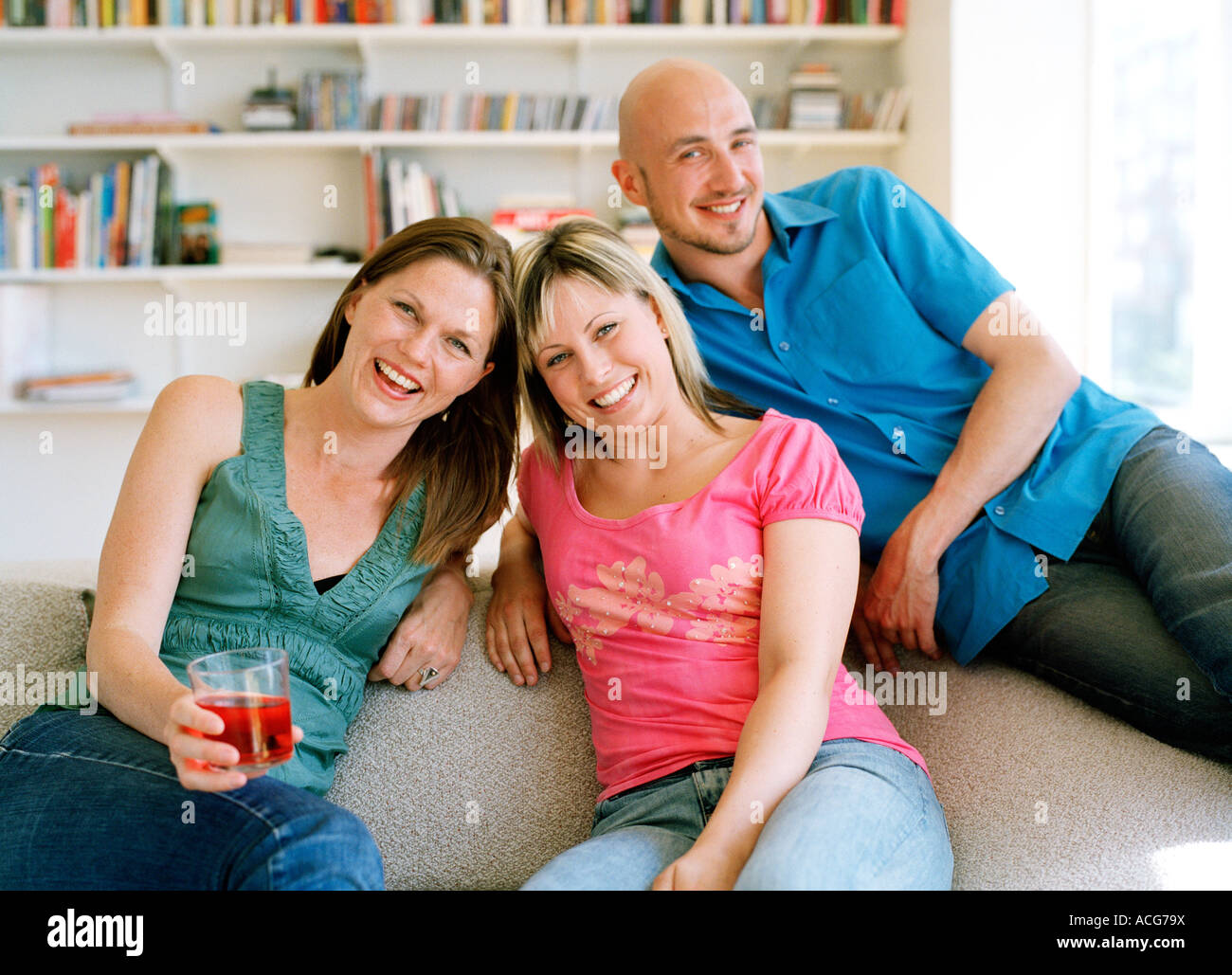 Three people in a sofa Stock Photo - Alamy