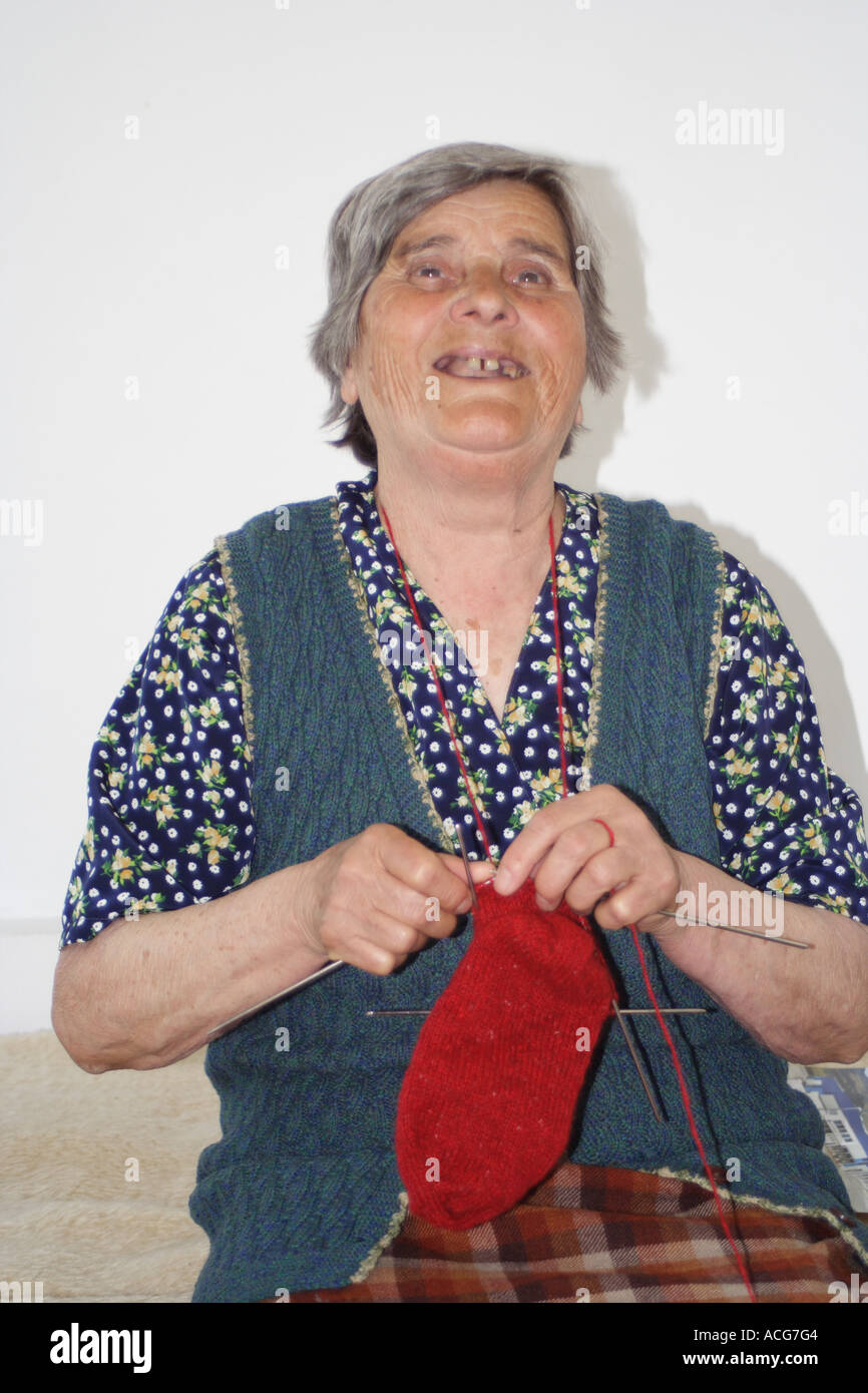Old Woman knit a socks and smiling Stock Photo - Alamy