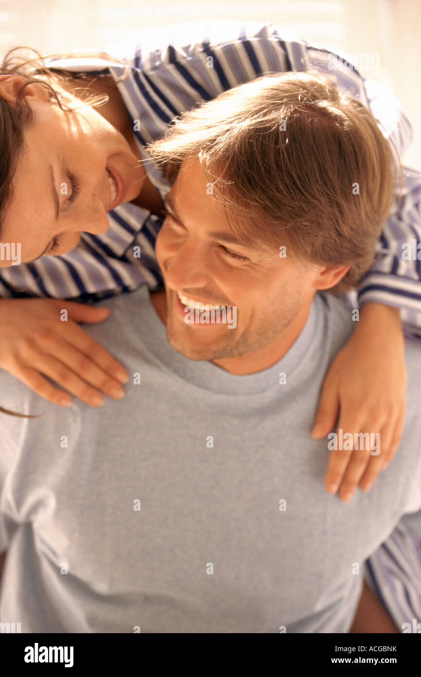 Woman leaning against man's back both smiling Stock Photo - Alamy