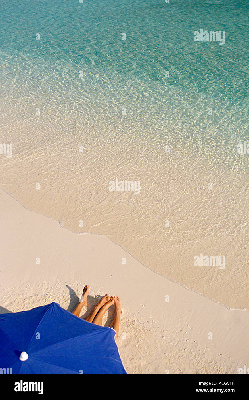 Maldives elevated view on couple's feet under parasol Stock Photo - Alamy