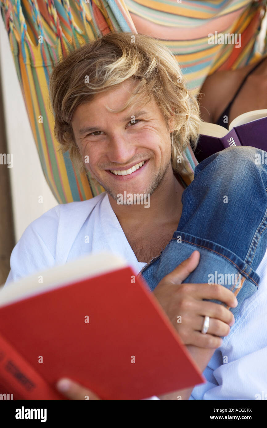 A smiling man looking at the camera holding a book Stock Photo - Alamy