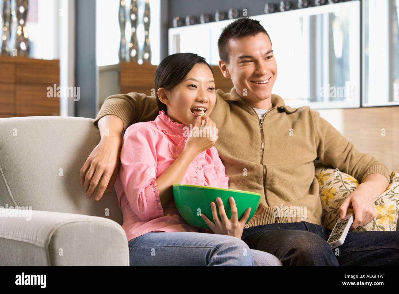 Asian couple watching television Stock Photo - Alamy