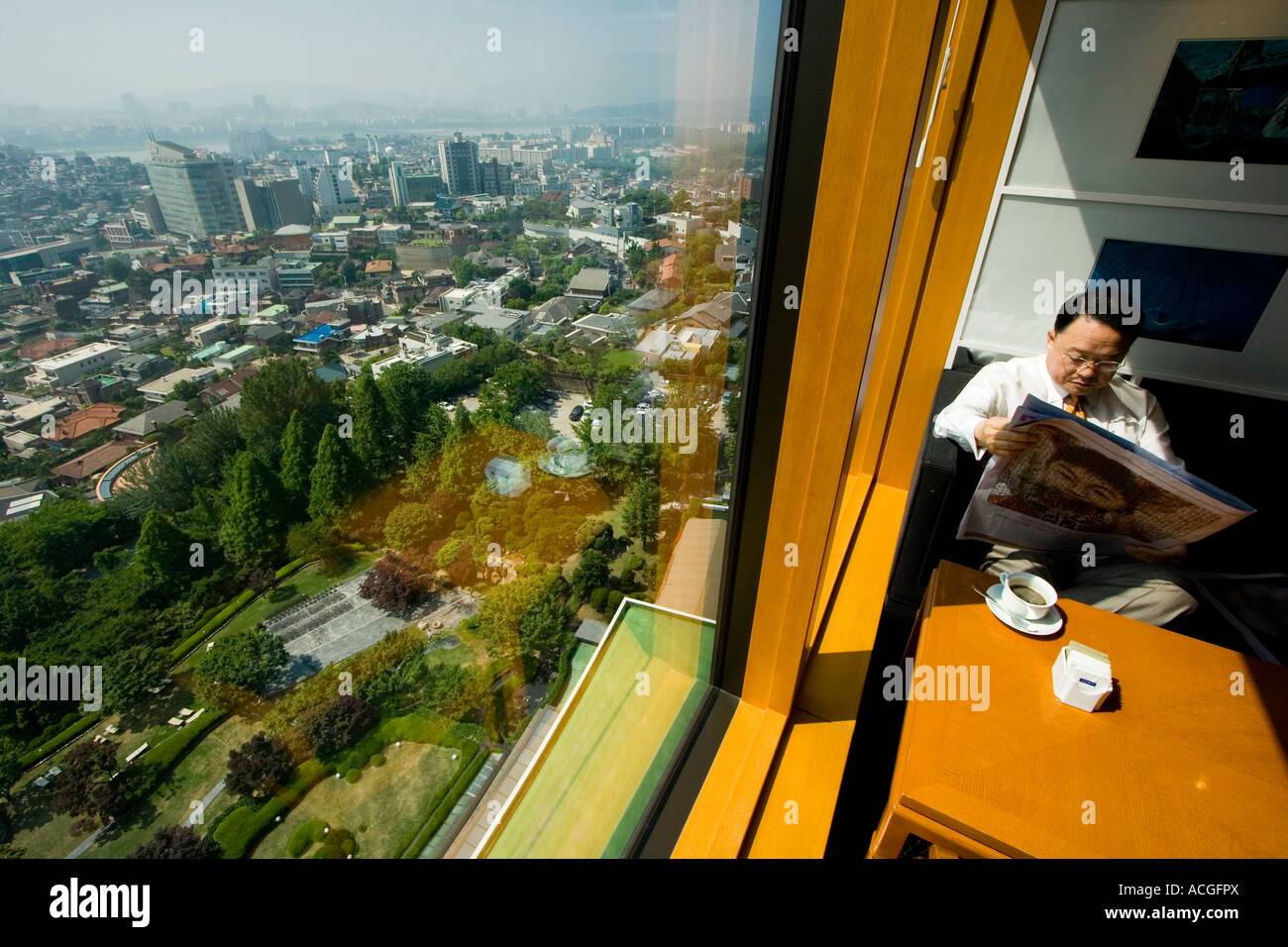 Korean Businessman in Suit reading Newspaper with View over Seoul South ...