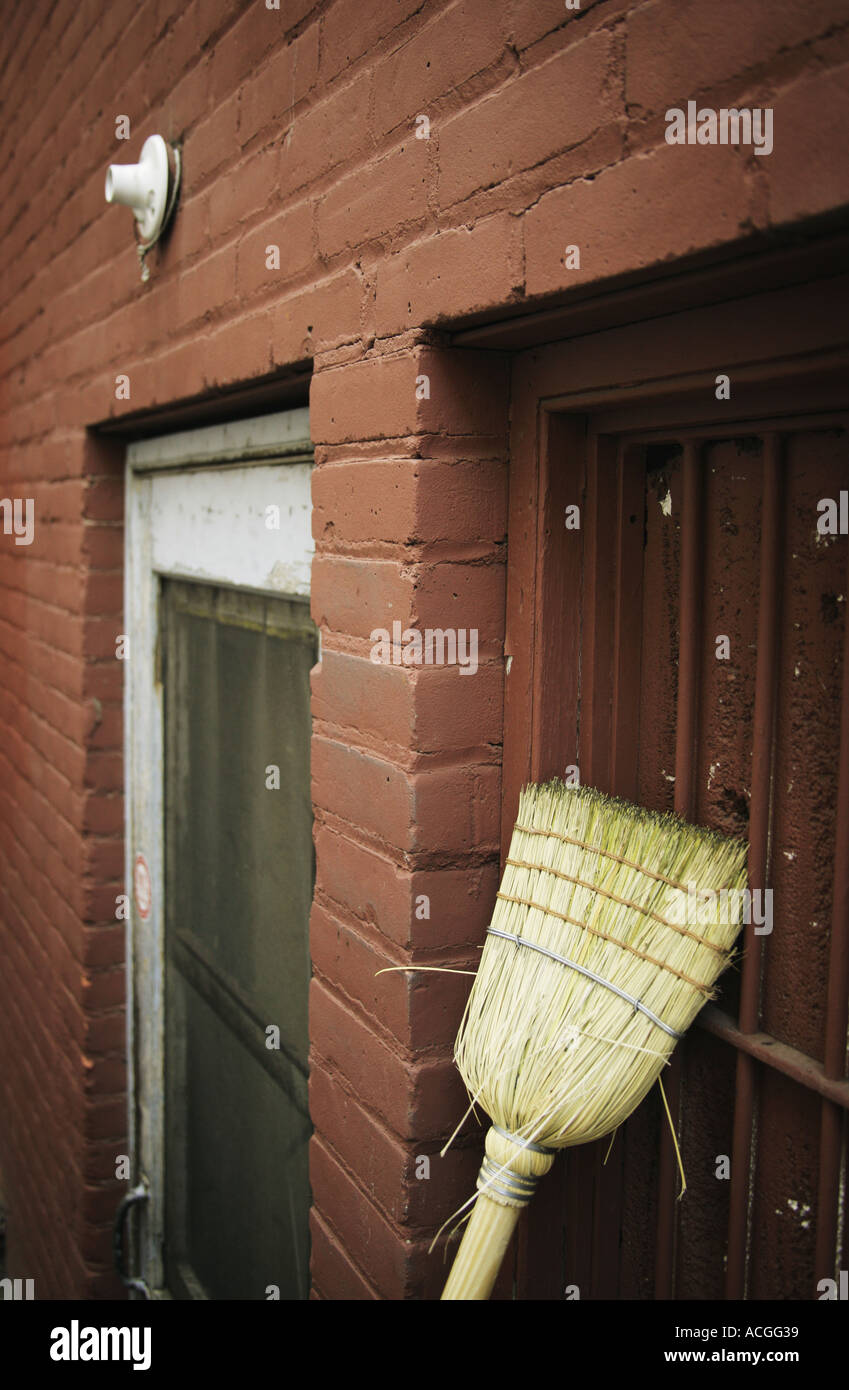 Broom leaning against an exterior wall Stock Photo - Alamy