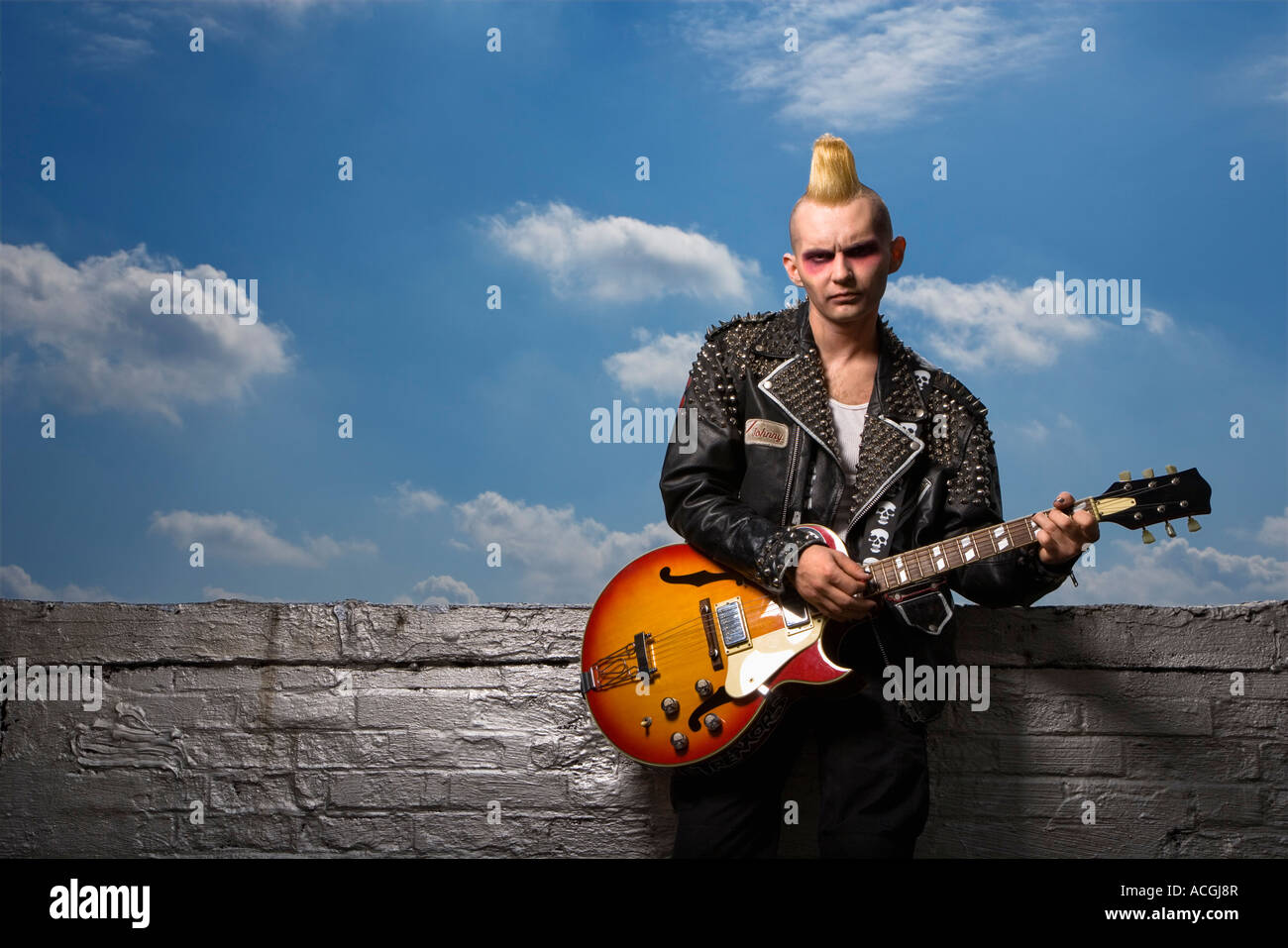 Portrait of mid adult Caucasian male punk holding guitar Stock Photo ...