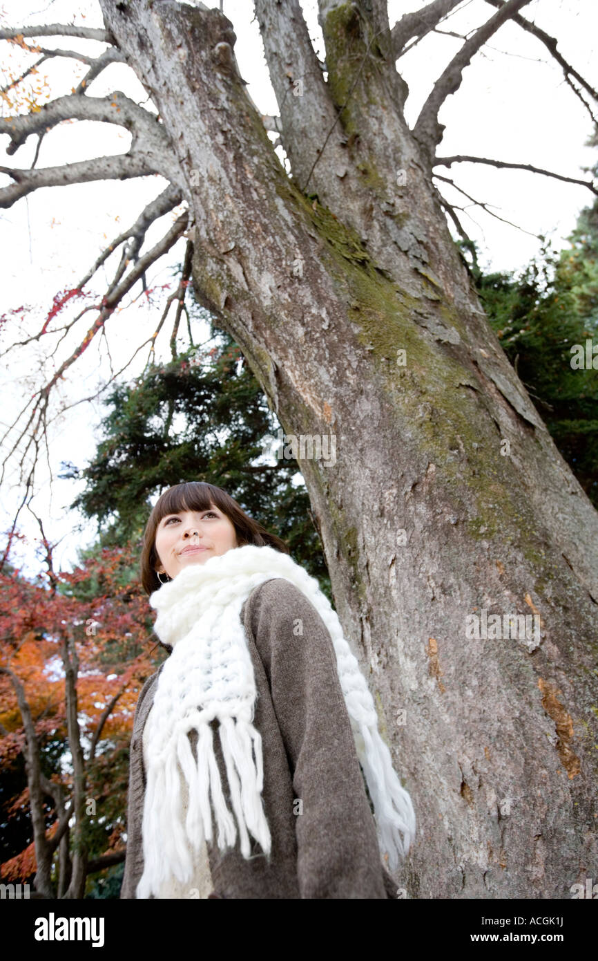 Young woman standing under tree Stock Photo - Alamy