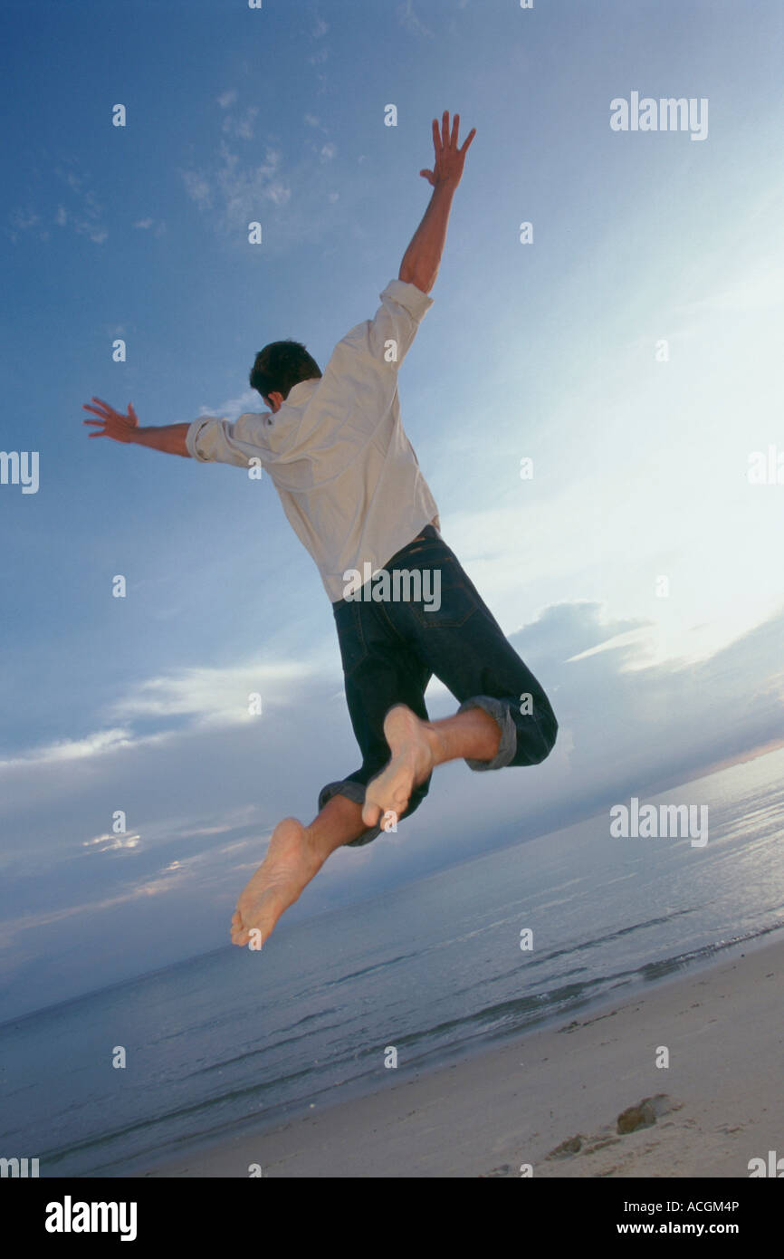 Man s back jumping on beach Stock Photo - Alamy
