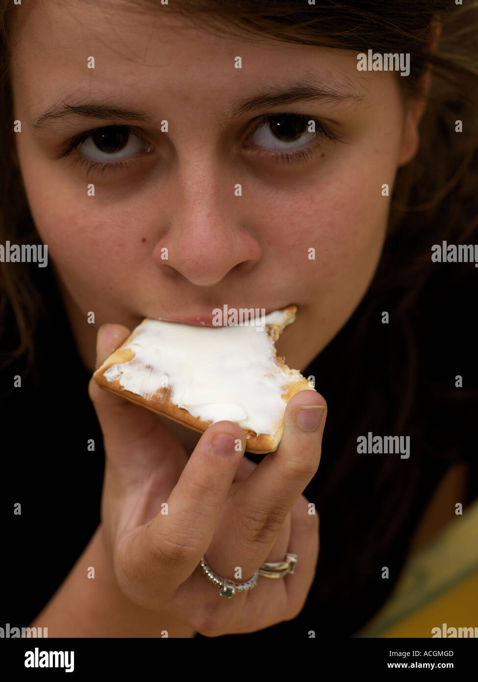 Girl Eating a Cracker with Cream Cheese Stock Photo - Alamy