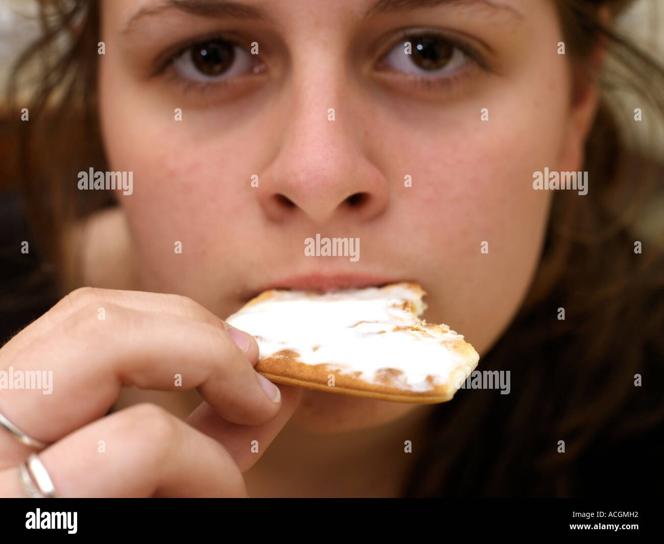 Girl Eating a Cracker with Cream Cheese Stock Photo - Alamy