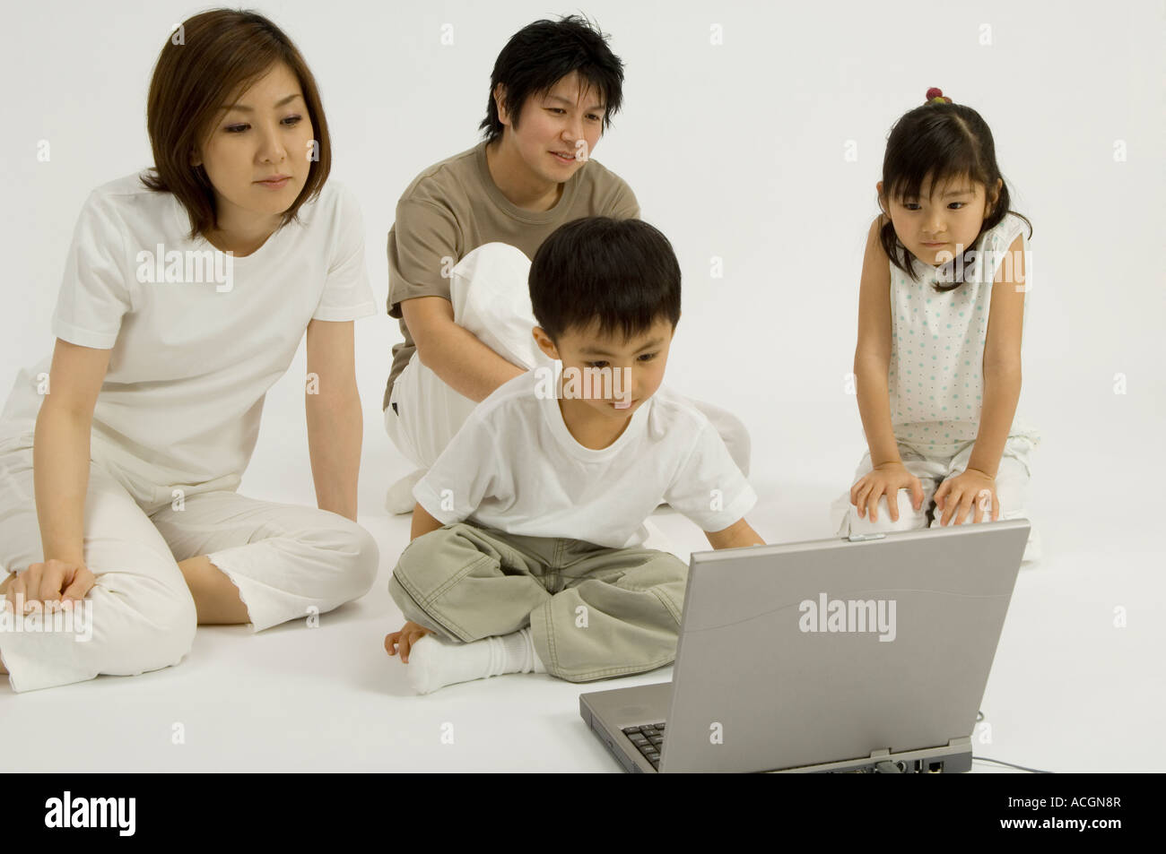 Family watching son use computer Stock Photo - Alamy