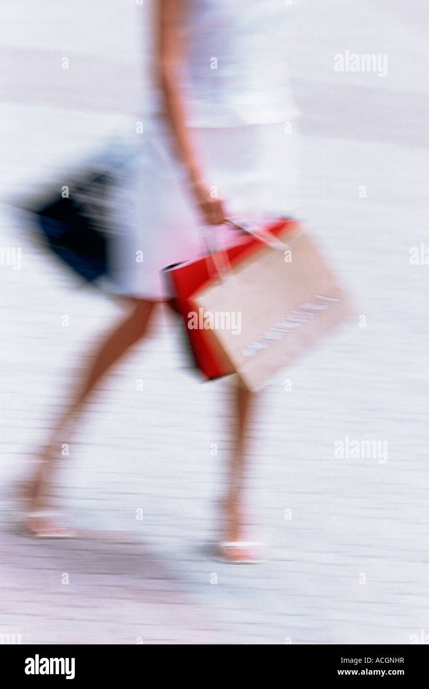 Woman in white skirt and tee shirt walking down the street Stock Photo ...