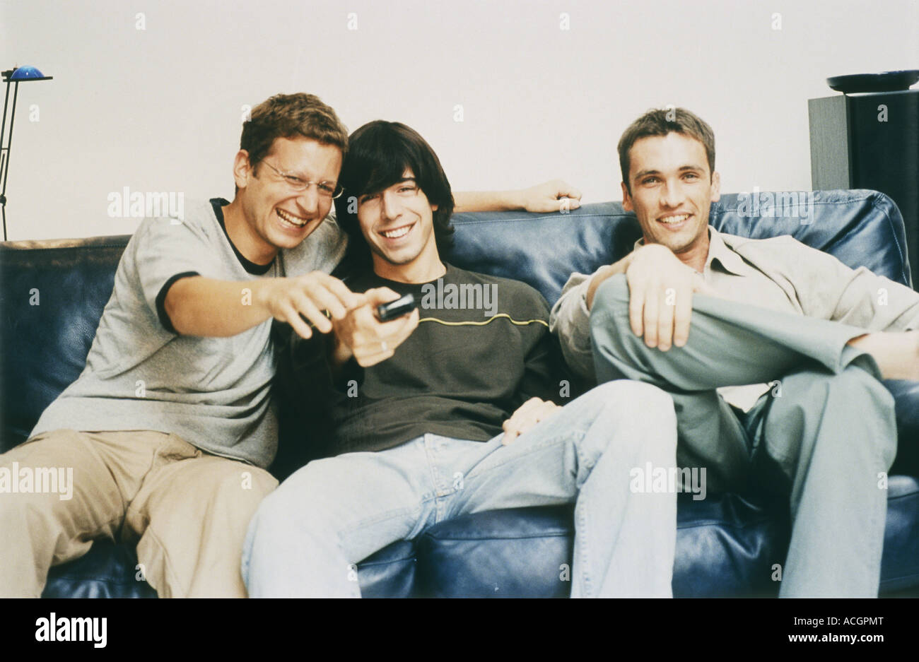Smiling men watching television remote control Stock Photo - Alamy