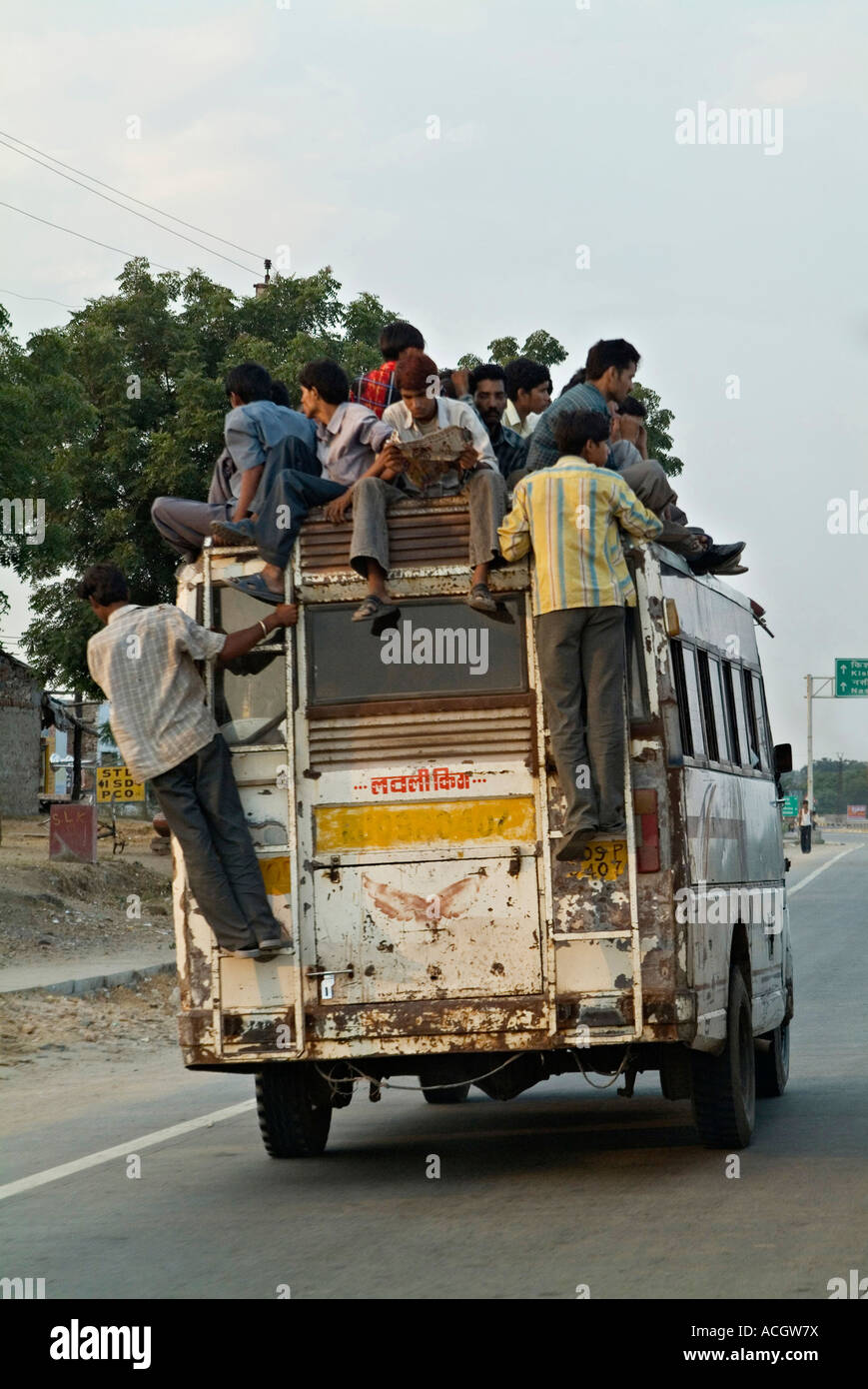 A MINI BUS OVERLOADED AND PASSENGERVARE SITTING ON TOP OF ROOF Stock ...
