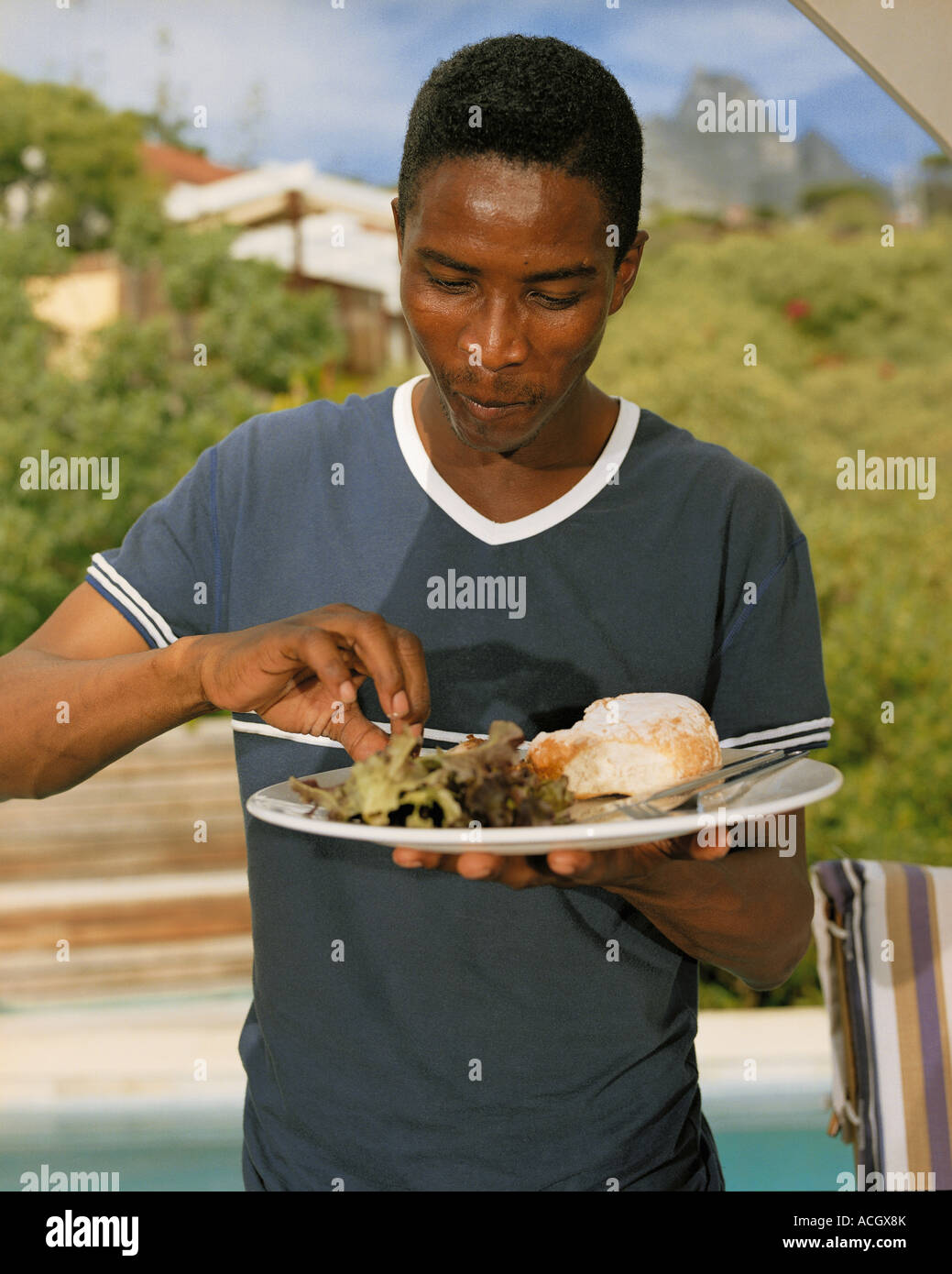 Portrait man standing eating plate in his hand Stock Photo - Alamy