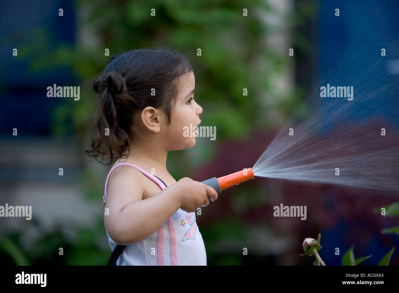 Little girl with a garden hose Stock Photo - Alamy