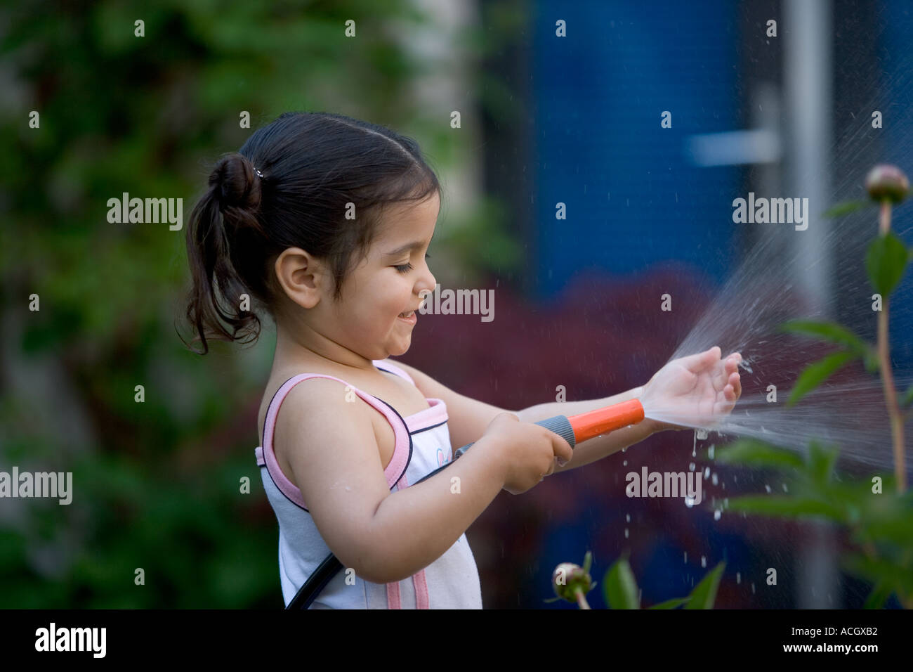 Little girl with a garden hose Stock Photo - Alamy
