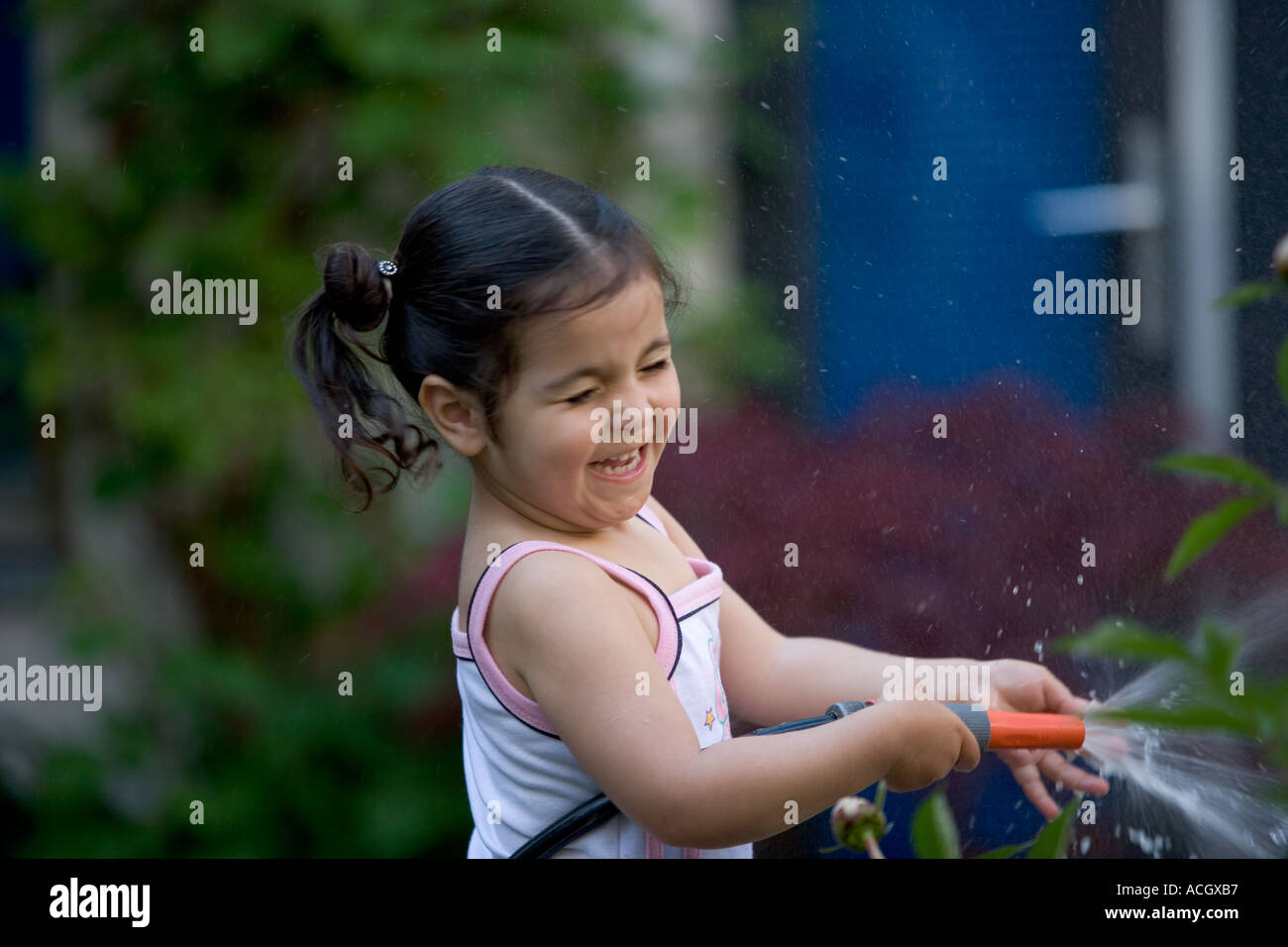Little girl with a garden hose Stock Photo - Alamy