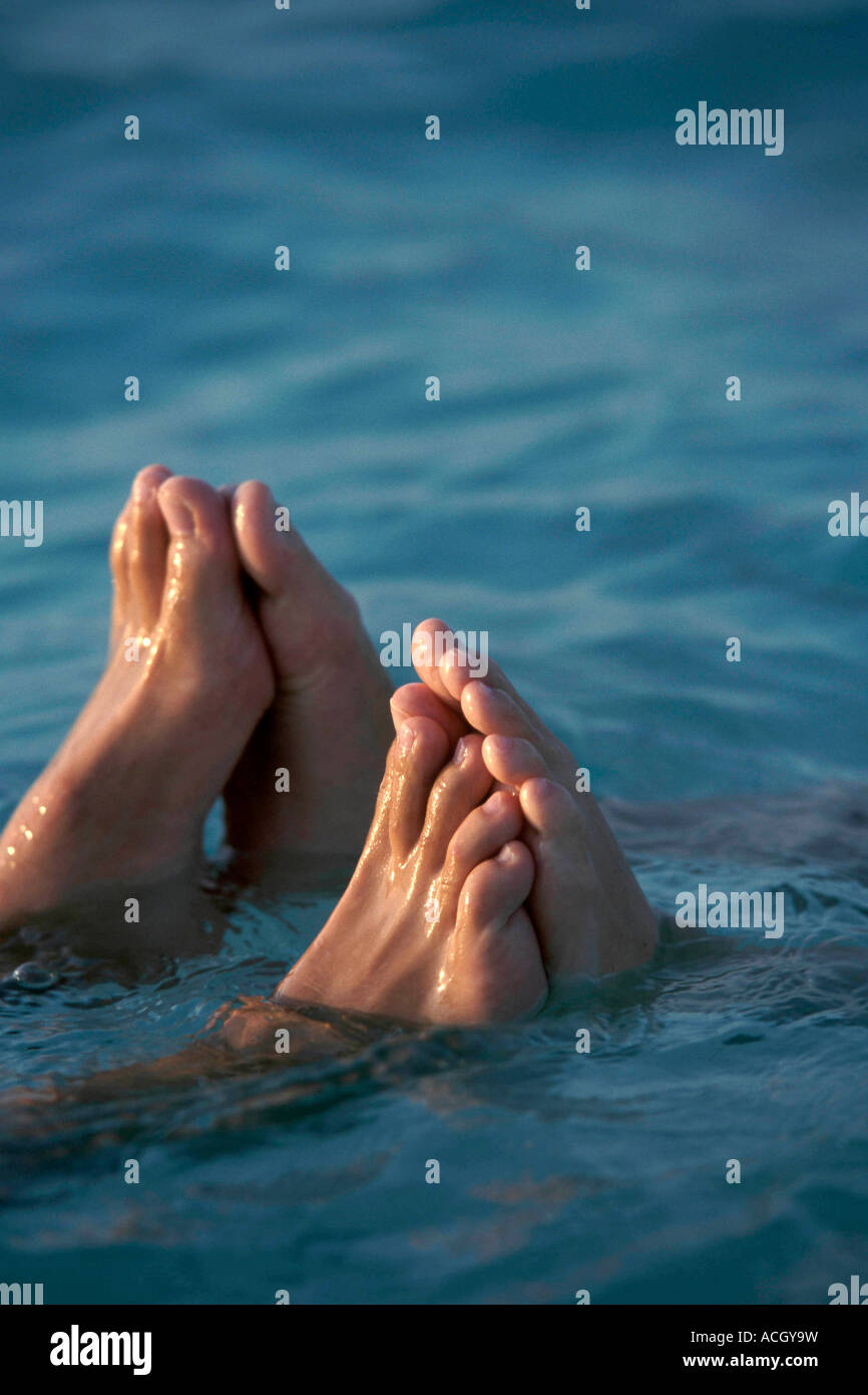 Close up on couple s feet on water sea Stock Photo - Alamy