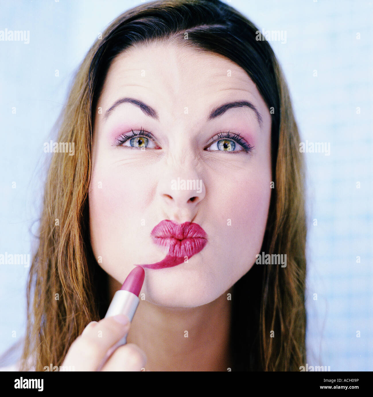 Portrait woman putting lipstick trace on chin Stock Photo - Alamy