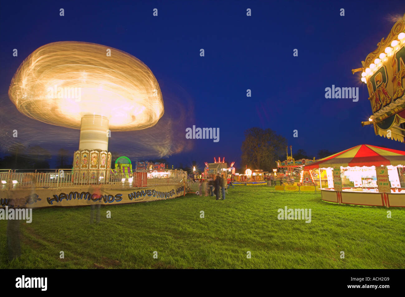 Fairground scene with fast spinning carousel Stock Photo - Alamy