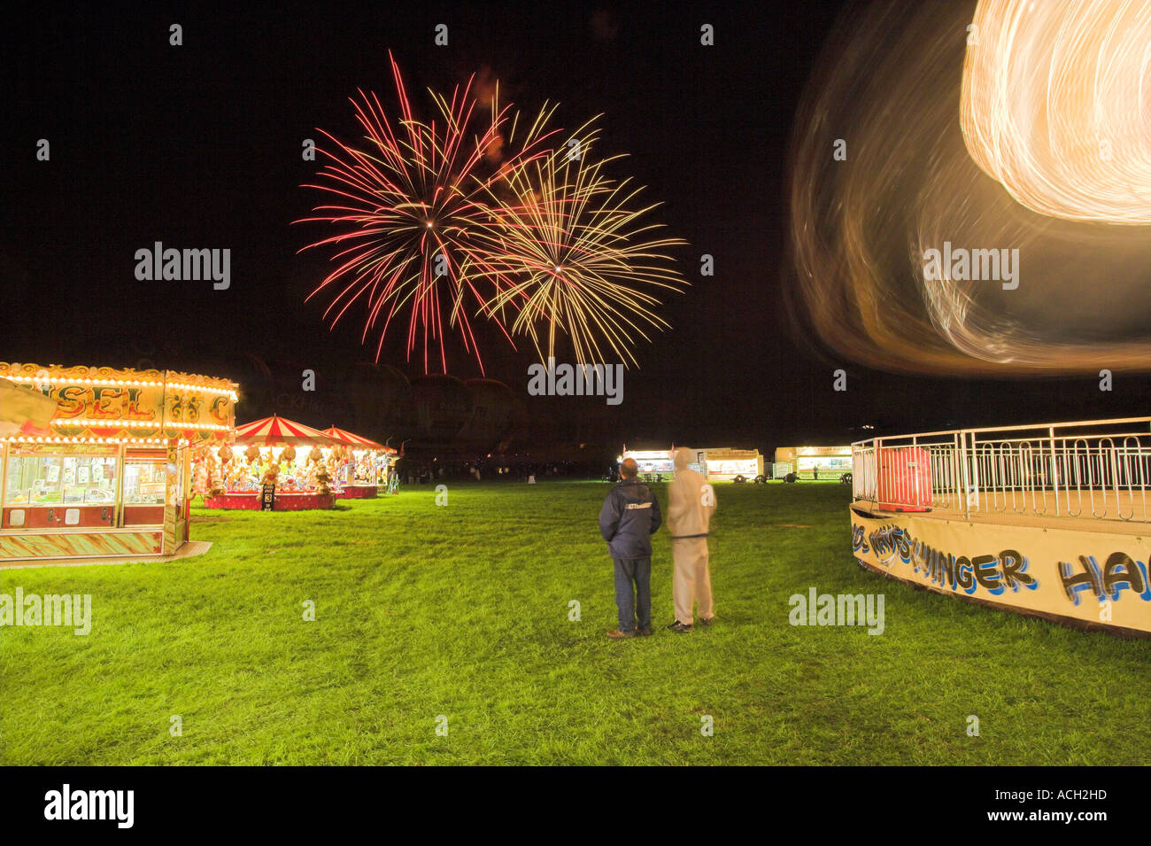 Fireworks and funfair at balloon spectacular Surrey with two onlookers ...