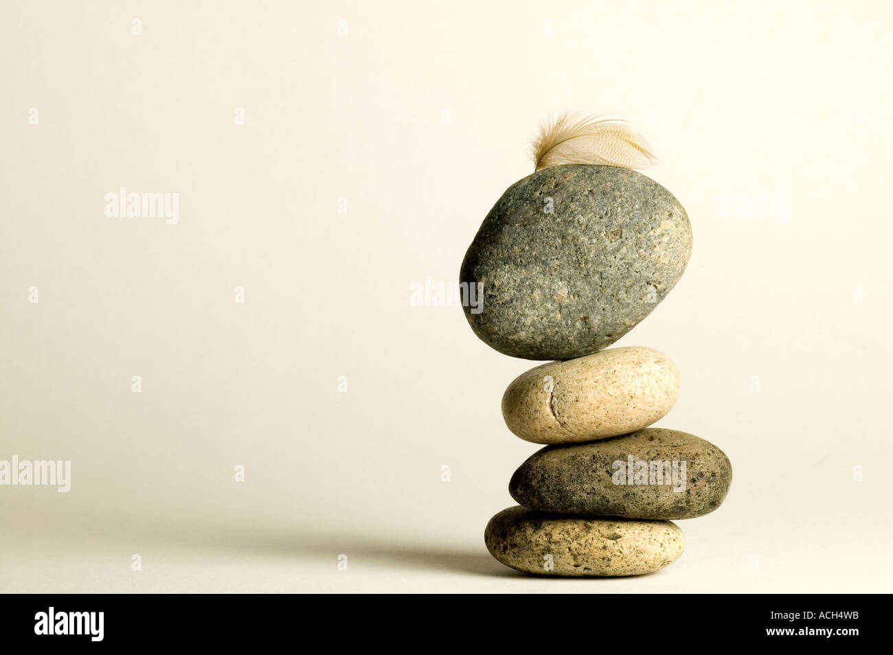 Stack of balanced rocks with feather on top Stock Photo - Alamy
