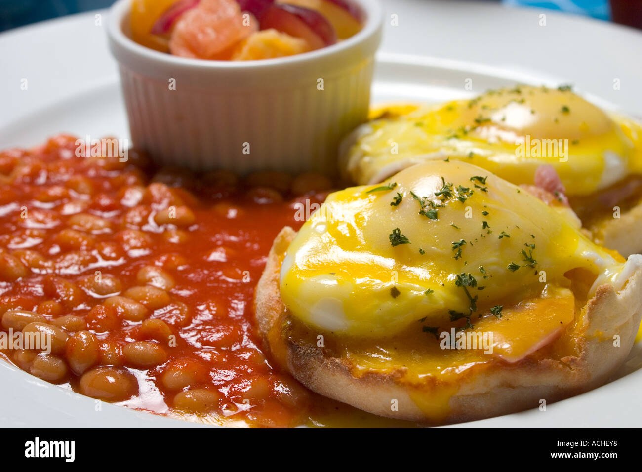 Eggs Benedict with baked beans and spiced apple on English muffin Stock ...