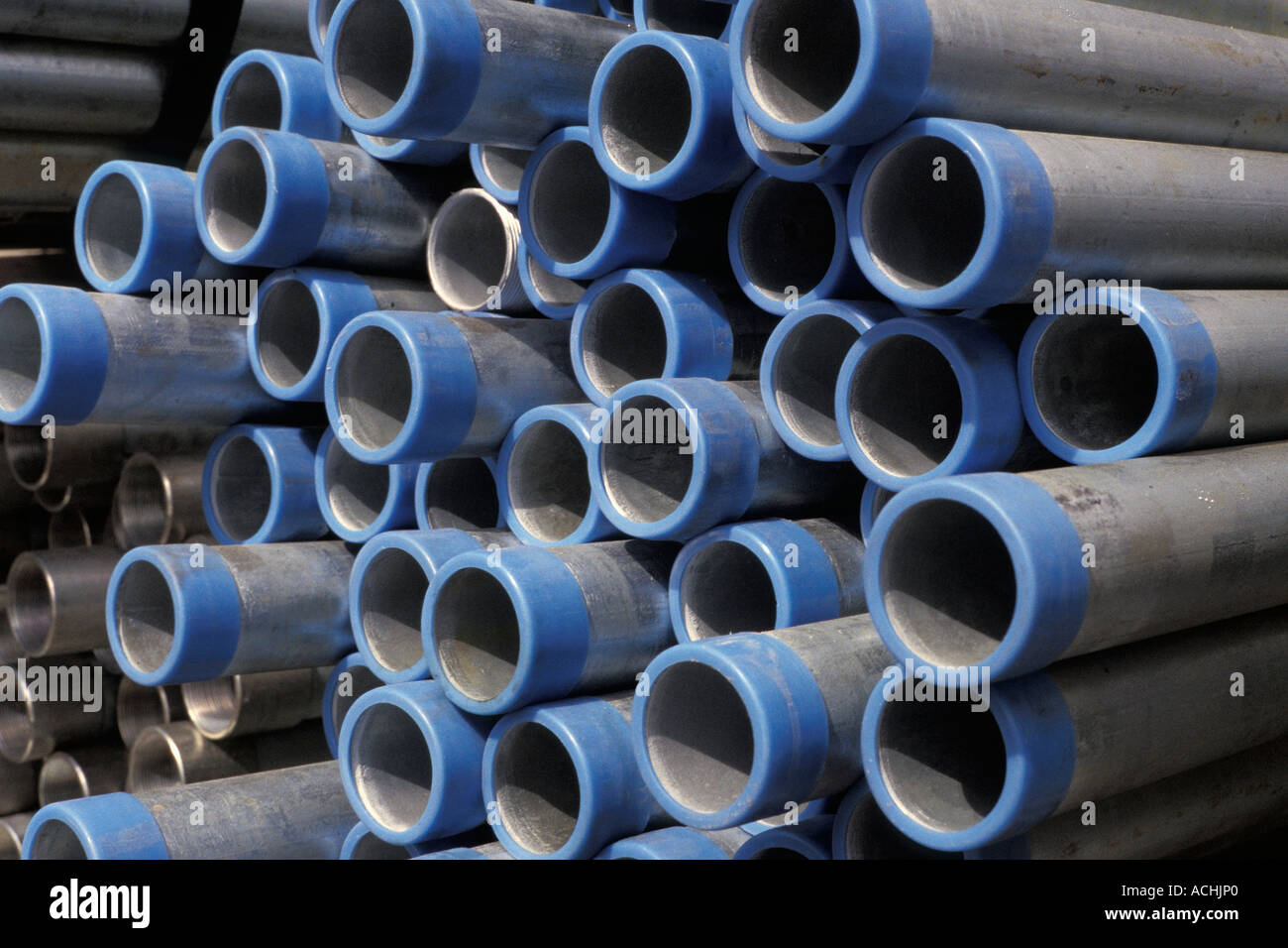 Metal pipe with blue plastic thread protectors in place Stock Photo - Alamy