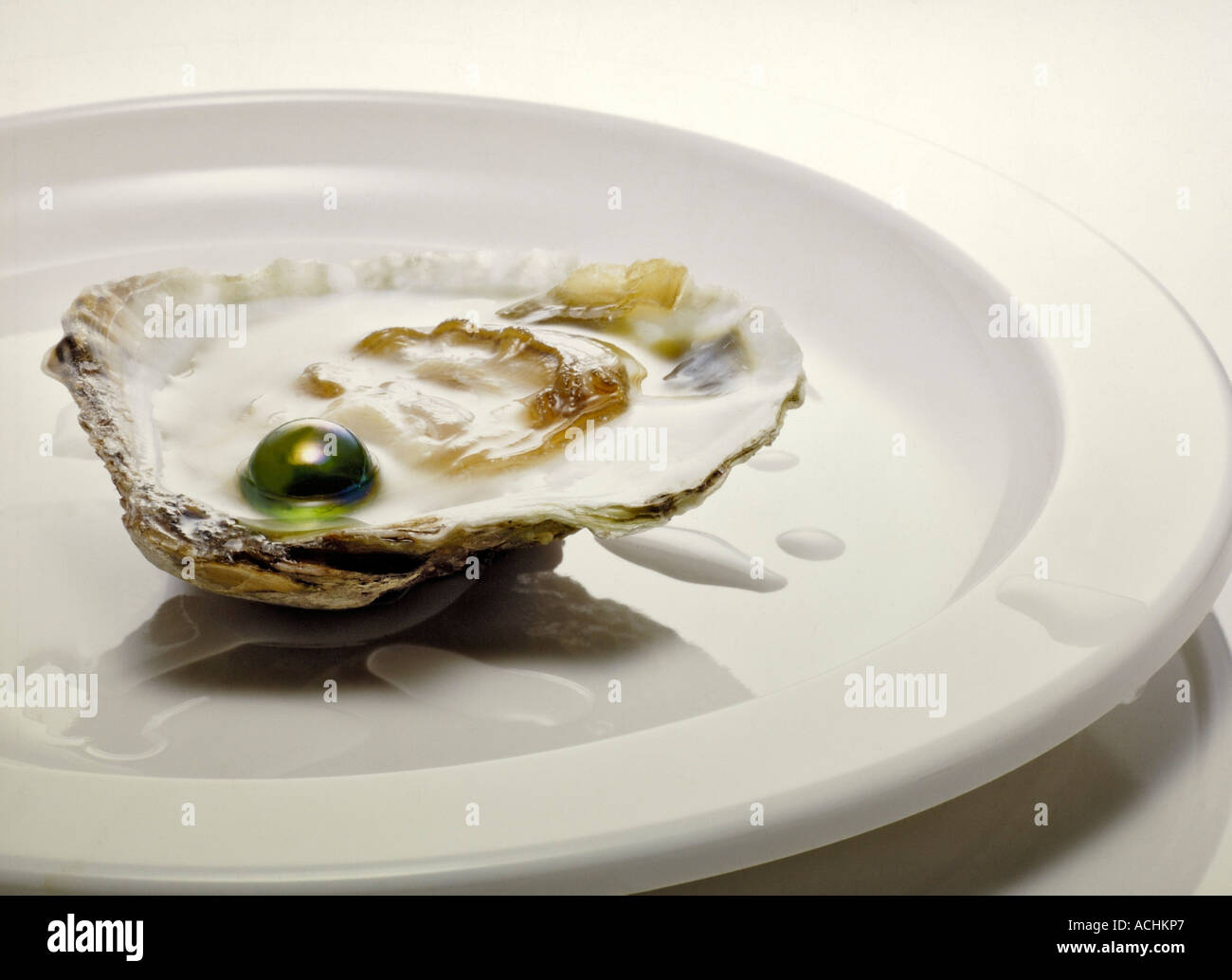 Oister with artificial pearl on a white plate Stock Photo - Alamy