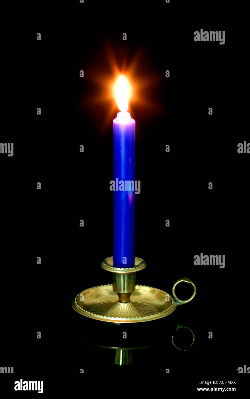 Blue candle burning in a brass holder Stock Photo - Alamy
