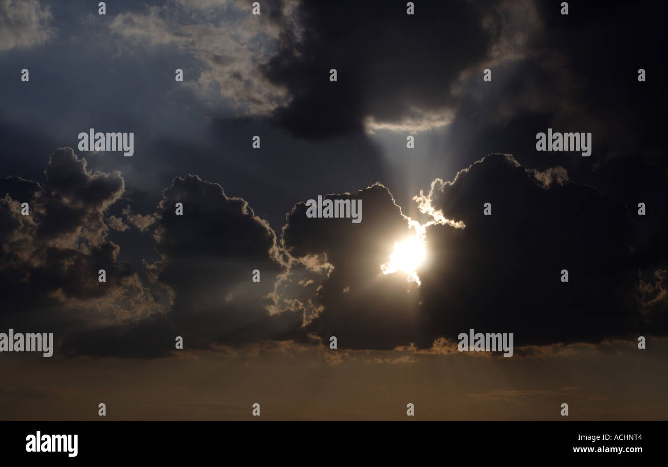 Sun behind storm clouds Stock Photo - Alamy