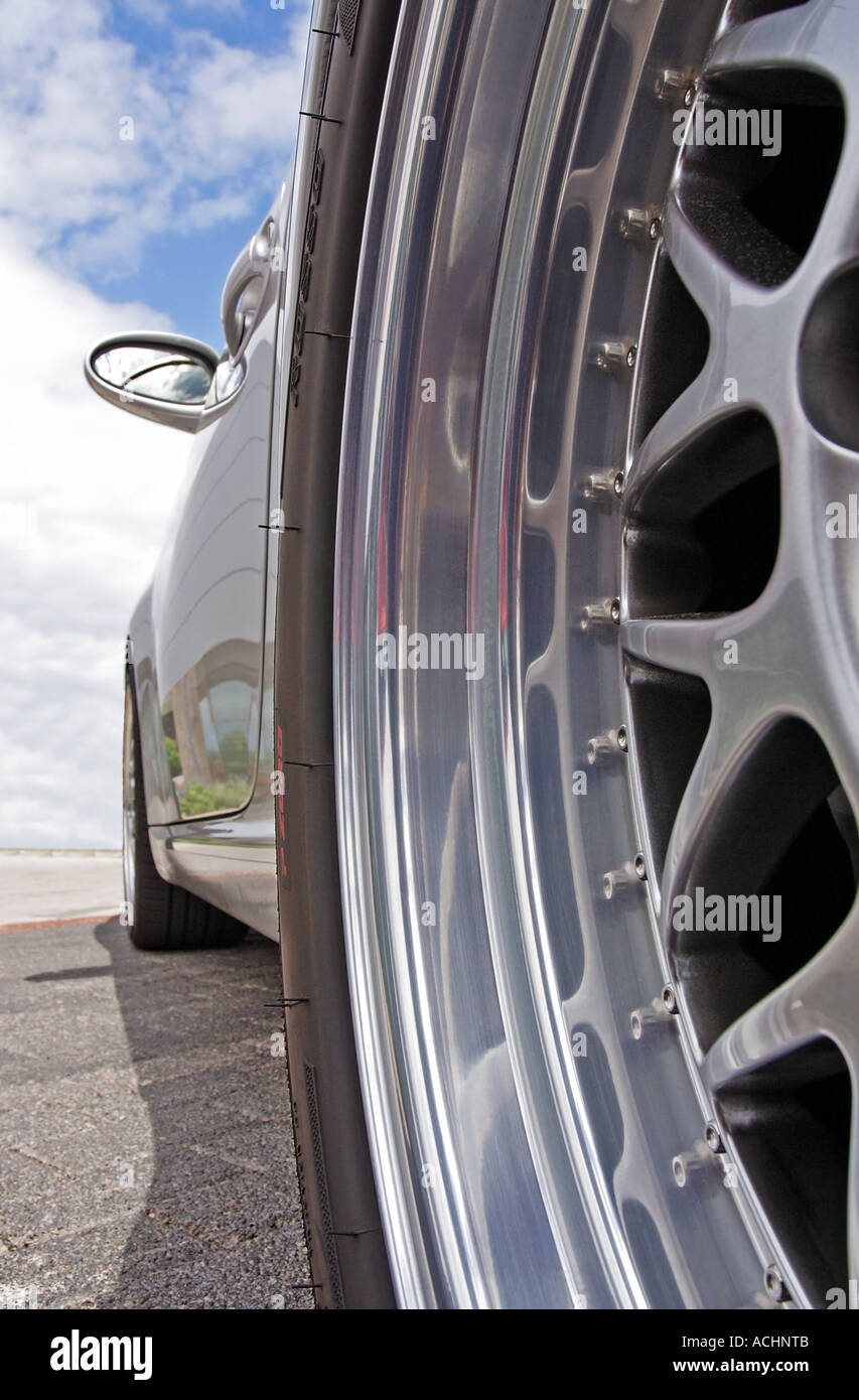 Wheel and rims of a silver sports car in a parking lot Stock Photo - Alamy